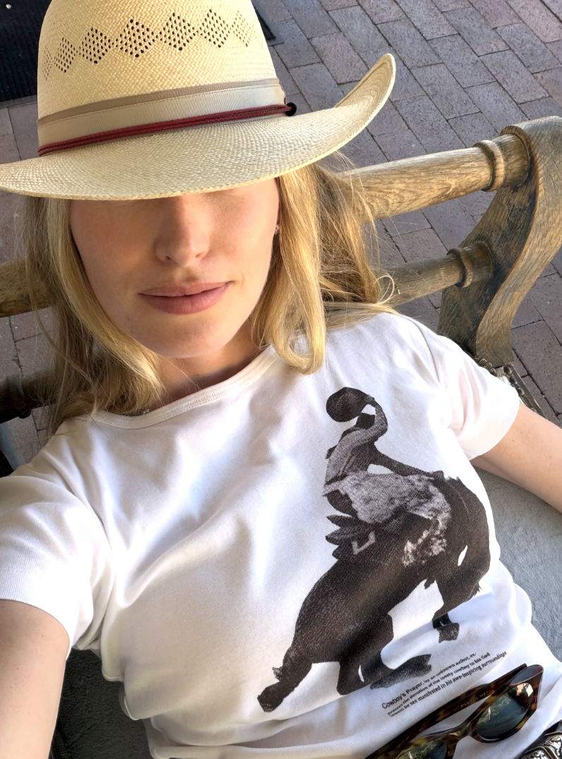 Chic straw cowboy hat with a maroon ribbon sits atop a model%27s blonde hair%2C paired with a playful graphic tee featuring a dinosaur.